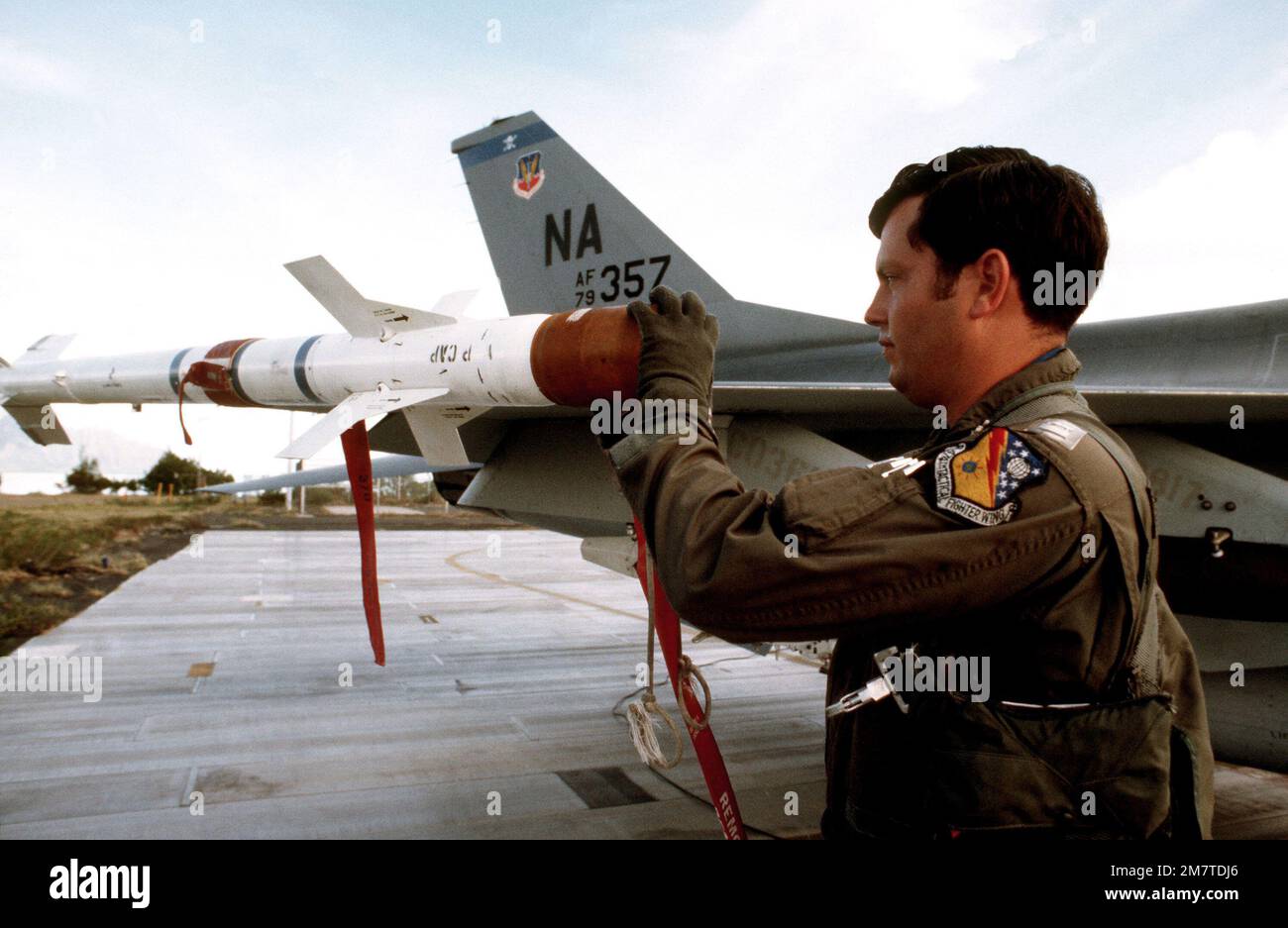 An F-16 Fighting Falcon aircraft pilot inspects an AIM-9 Sidewinder ...