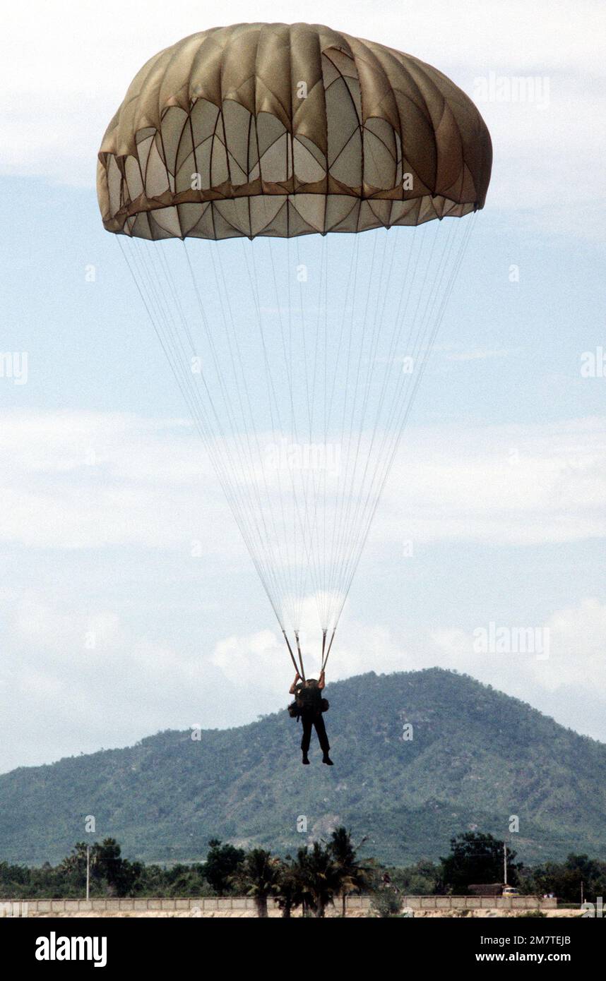 A paratrooper is approaching the ground after jumping from a C-130 ...