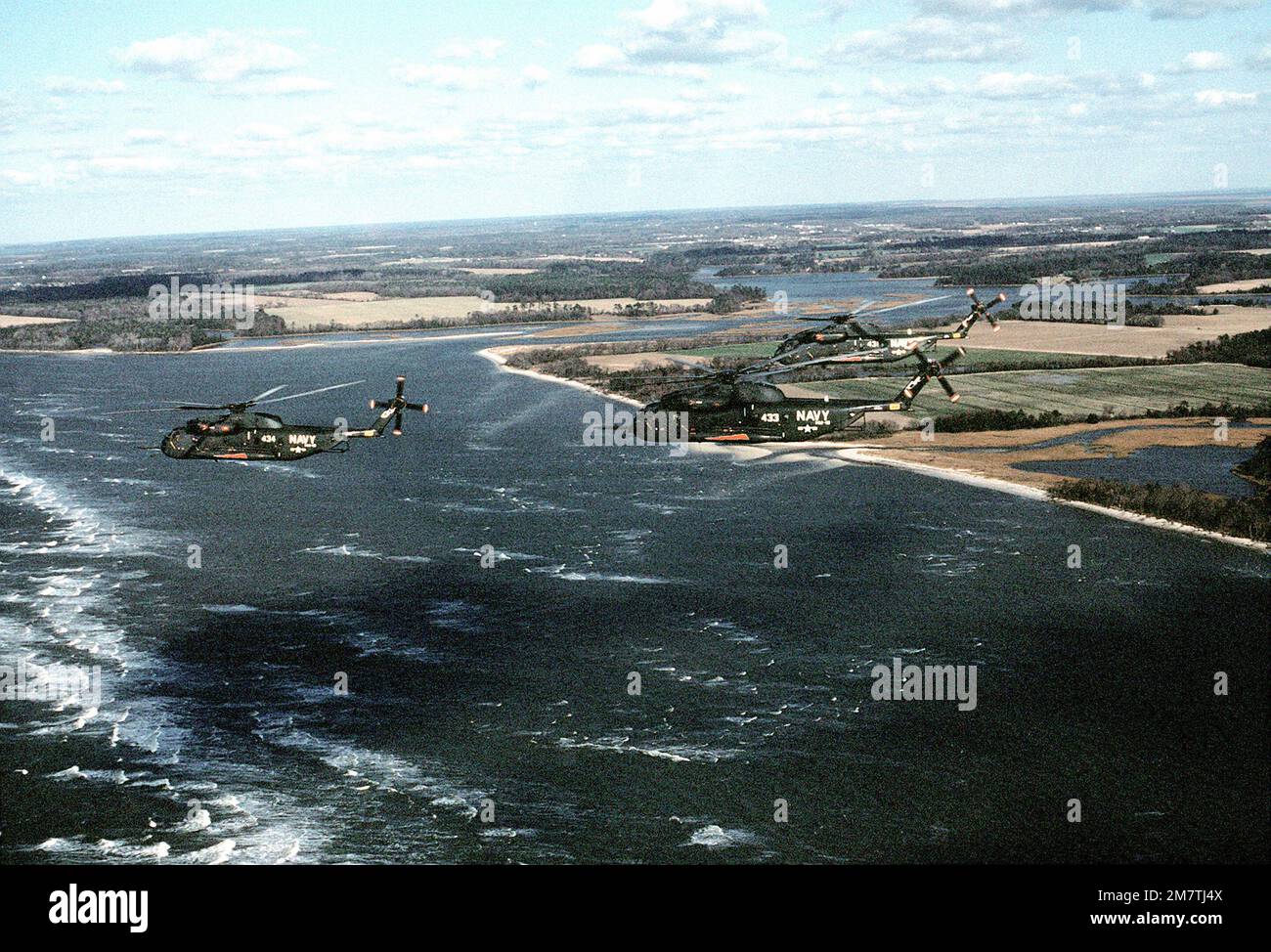 An air-to-air left side view of three RH-53D Sea Stallion helicopters ...