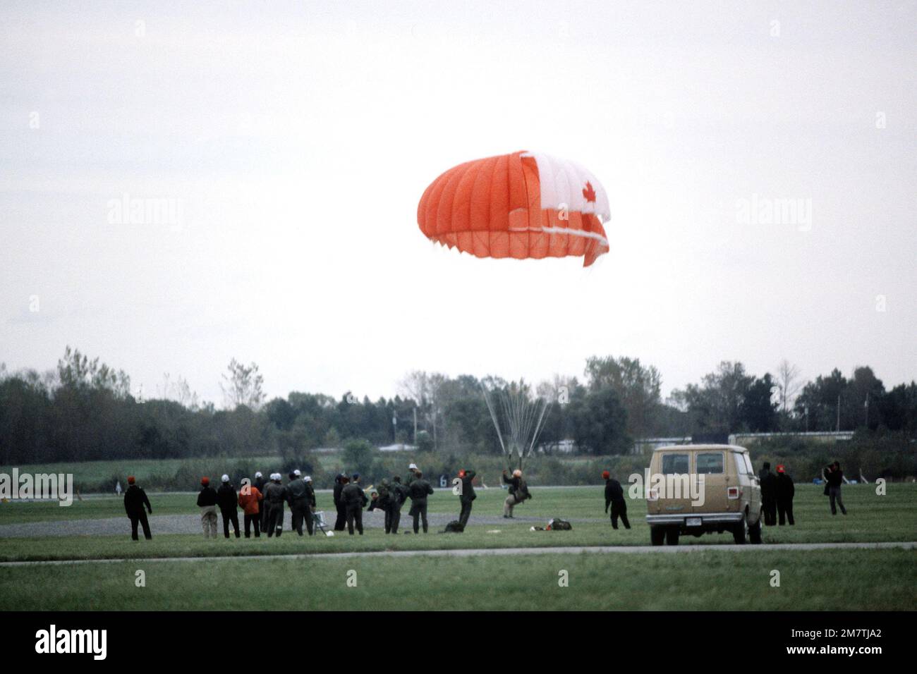 Sarex '81 participants gather on the ground after parachuting from a C ...