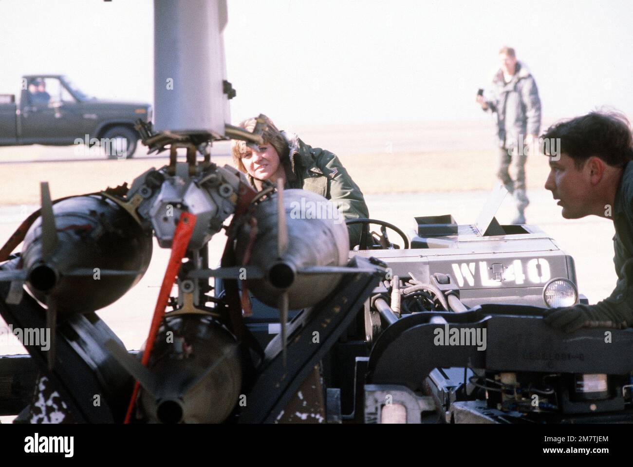 Ground crewmen line up a bomb loader to an F-16 Fighting Falcon ...