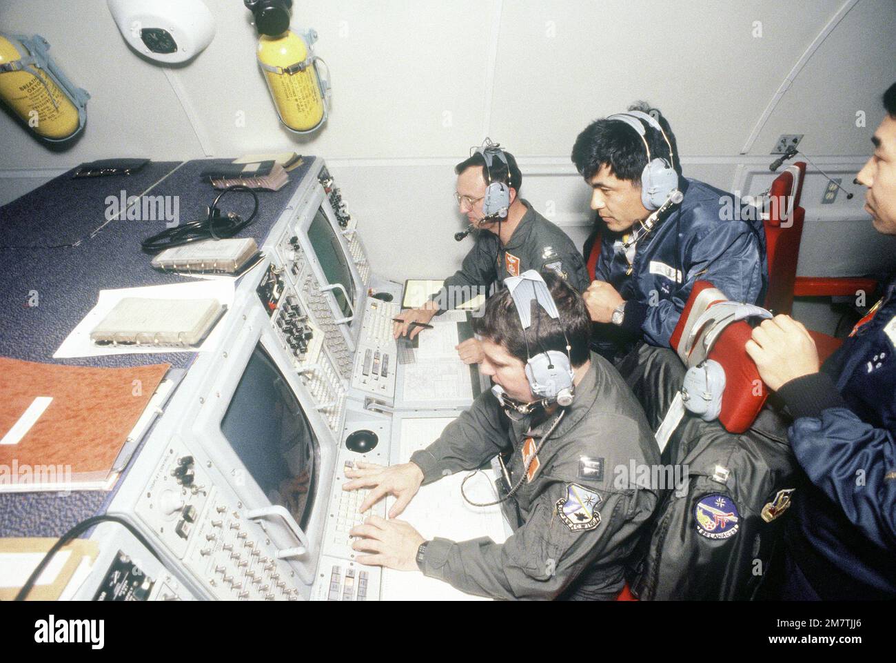 Captain John Chilcute foreground, and Captain Doug Fish work the E-3A ...