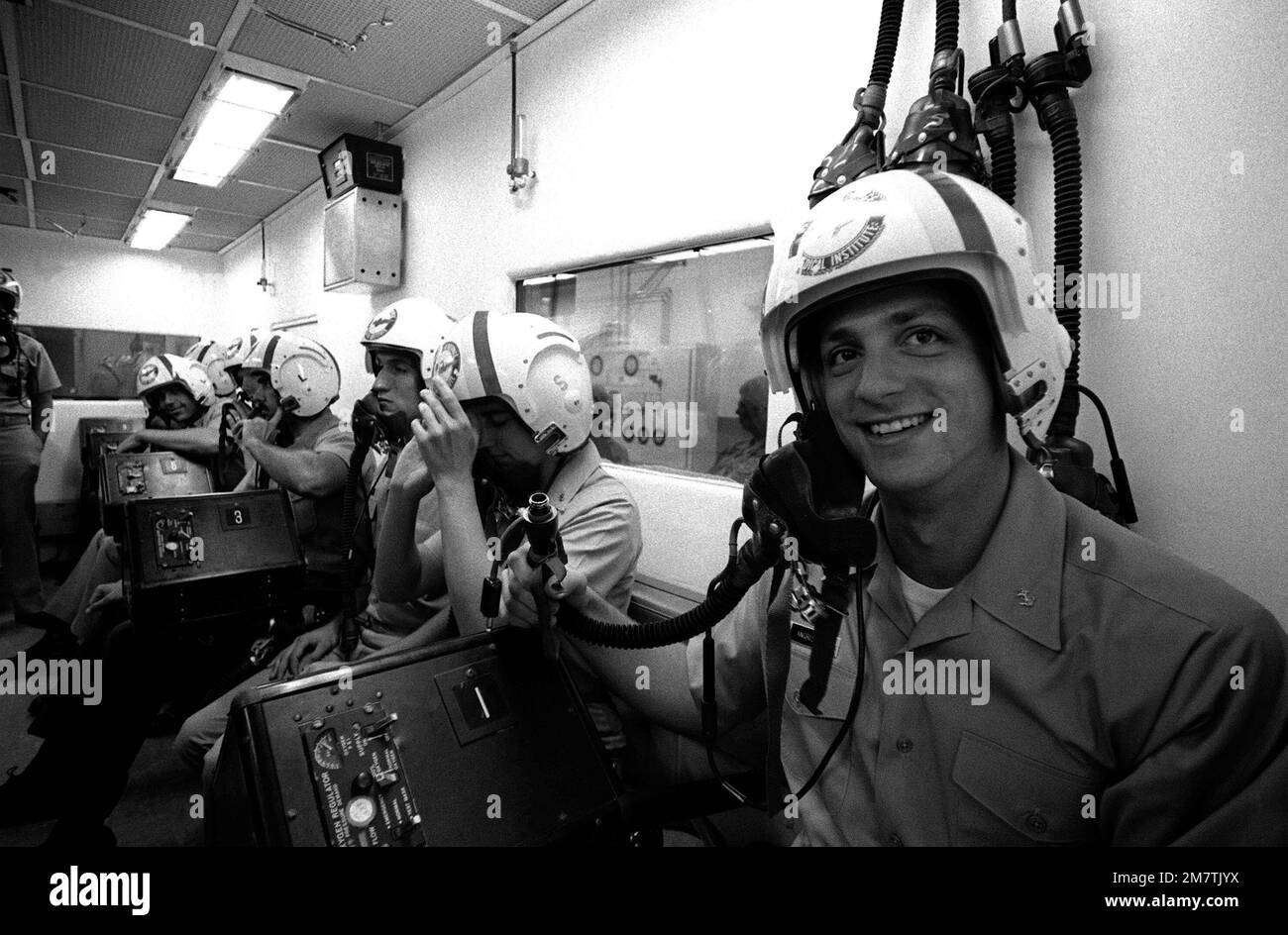 Candidates don helmets and oxygen masks for a pressure chamber exercise ...
