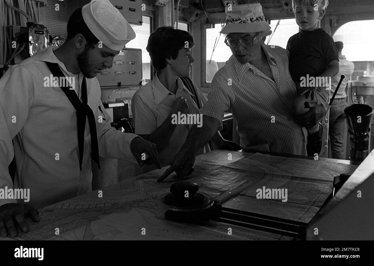 PO3 Gene Cooper Simpson shows navigational charts to his family during ...