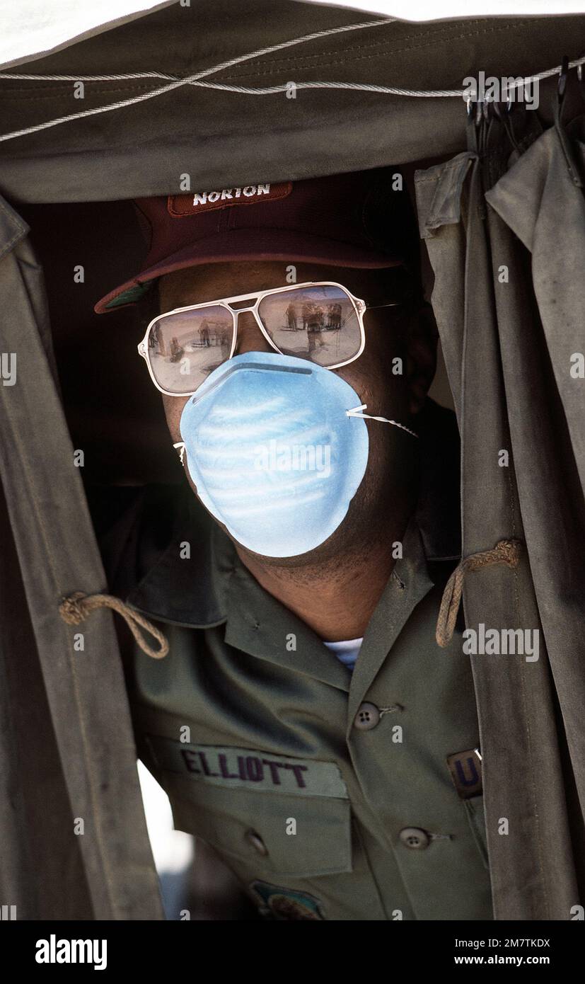 A crew member covers his face as the air is filled with desert dust by ...