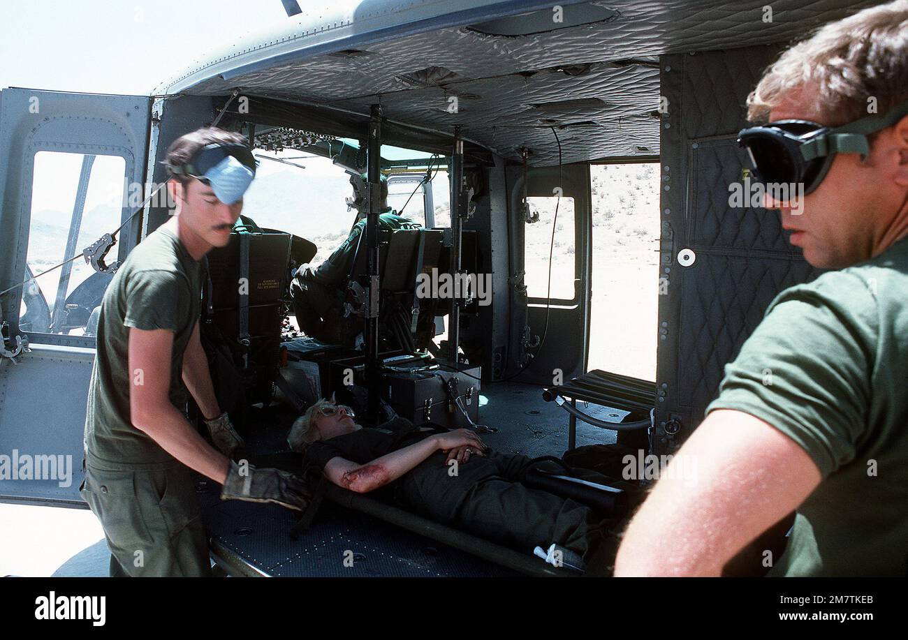 Crew members unload "casualty" from an Army UH-1 Iroquois helicopter in ...