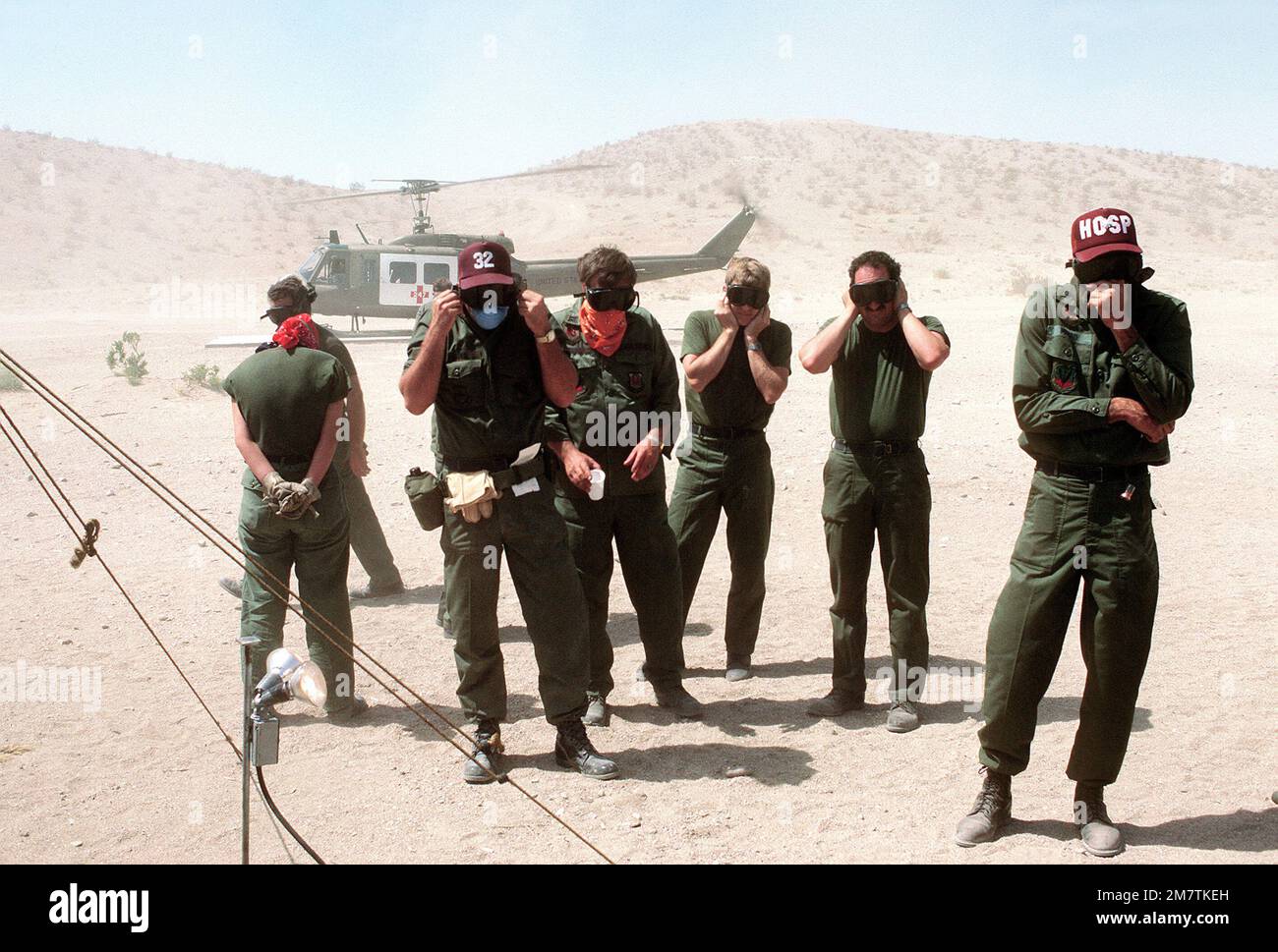 Crew members covers their faces as the air is filled with desert dust ...