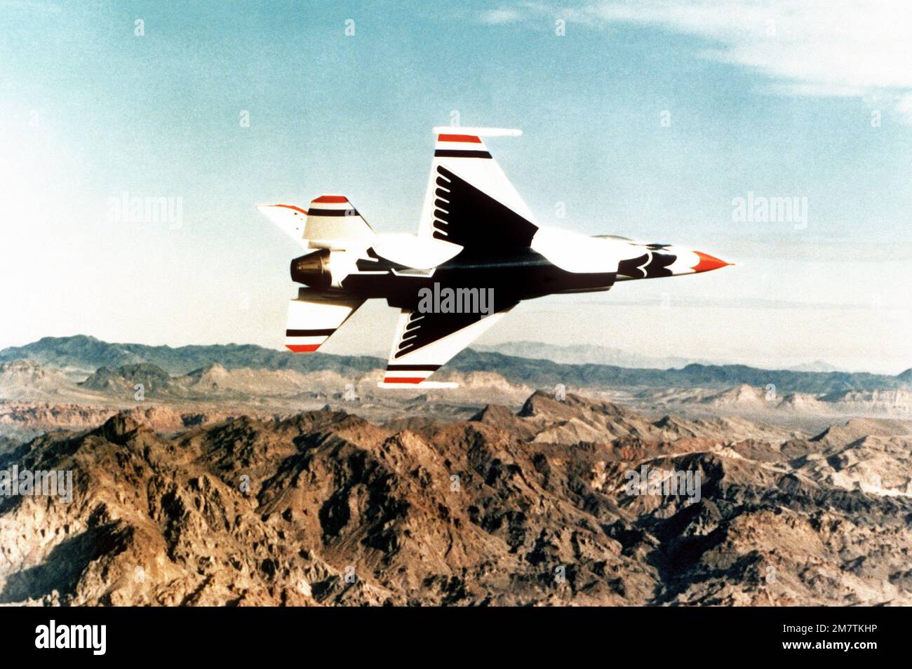 An air-to-air underside view of an F-16 Fighting Falcon aircraft ...