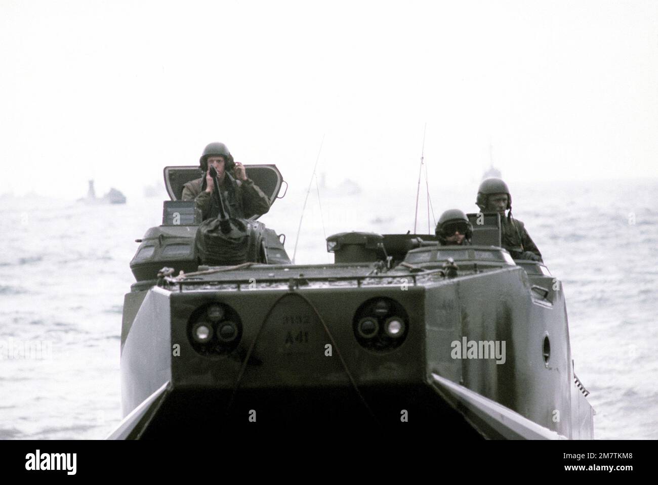 U.S. Marines, aboard a tracked landing vehicle (LVTP-7), land during ...