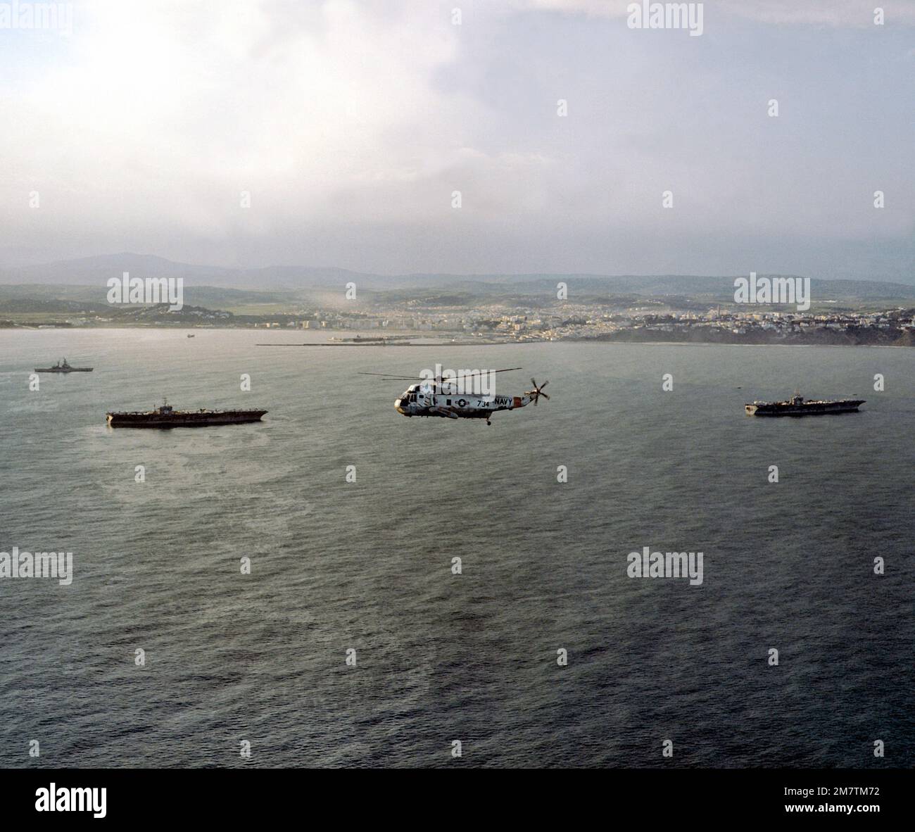 An air-to-air left side view of an SH-3 Sea King helicopter from ...