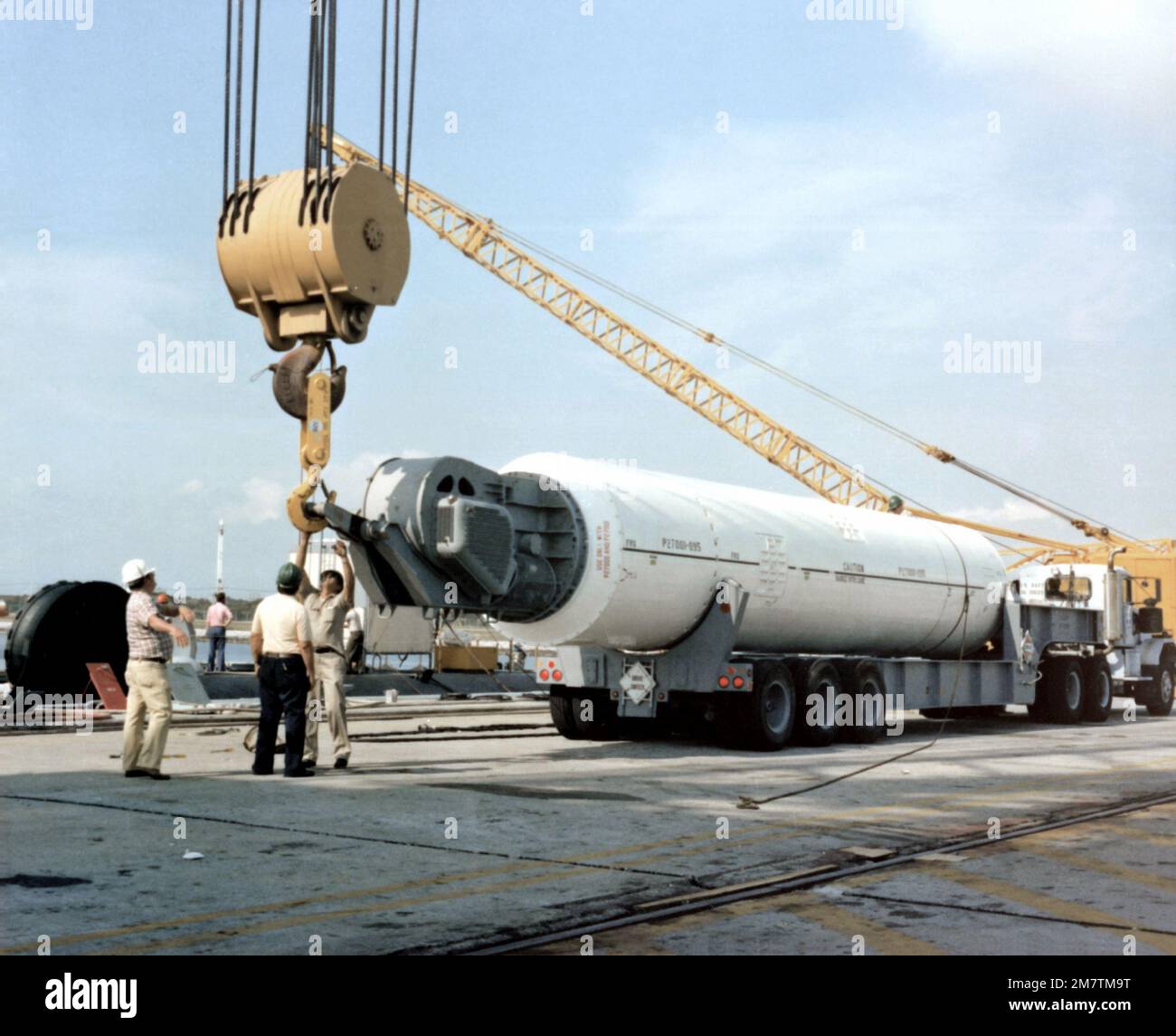 A crane prepares to lift a missile canister container aboard the ...
