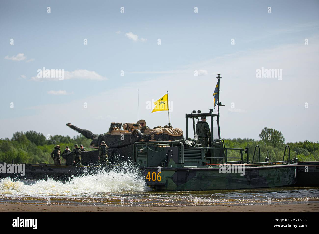 U.S. Soldiers and Swedish allies ferry a U.S. Army M1A2 Abrams tank ...
