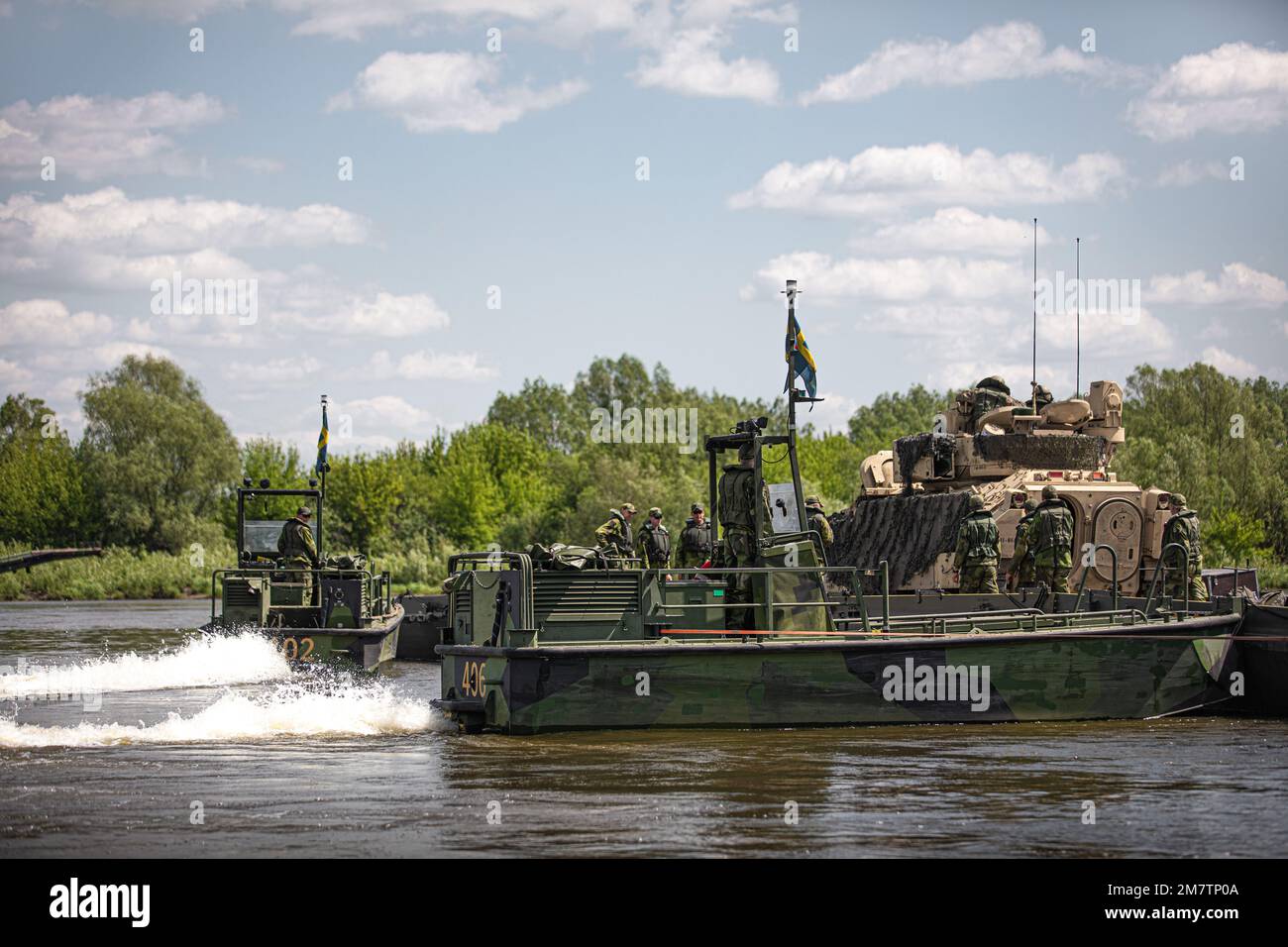 U.S. Soldiers and Swedish allies ferry a U.S. Army M1A2 Abrams tank ...