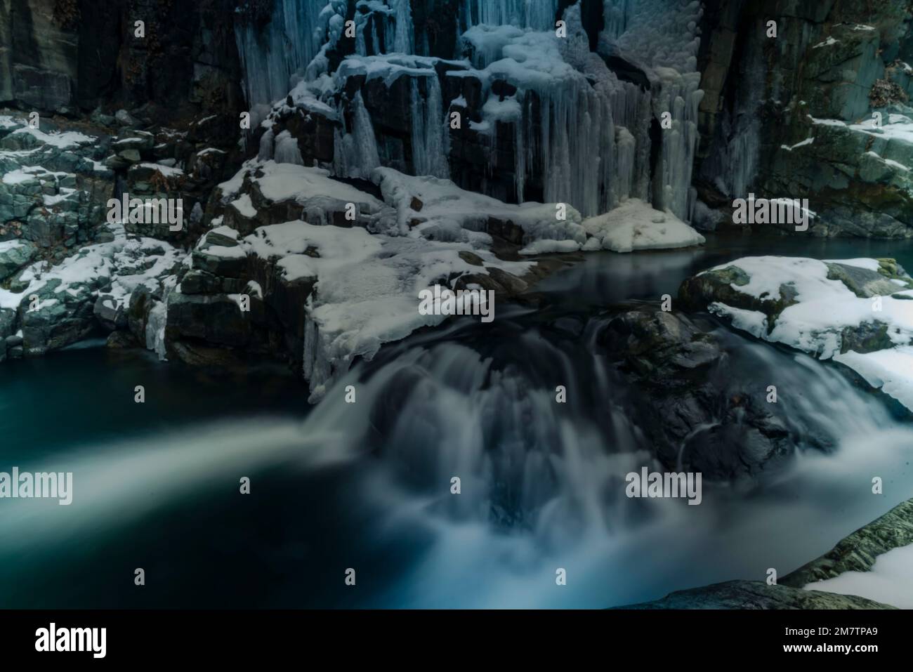 A long exposure shot of frozen Aharbal waterfall during a cold cloudy ...