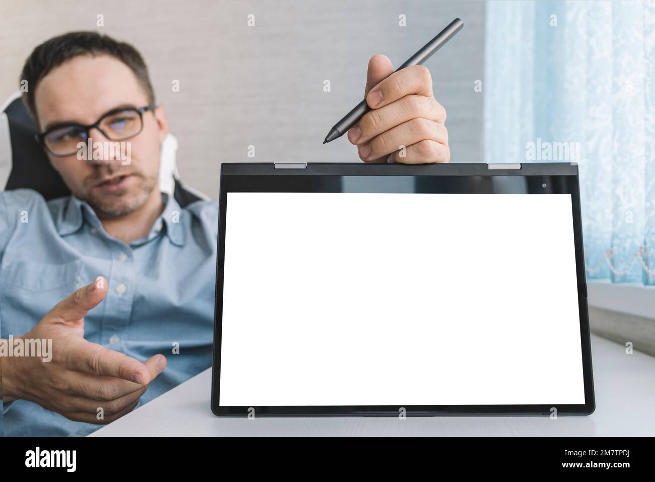 Young business consultant holding laptop with blank white screen. Mock ...