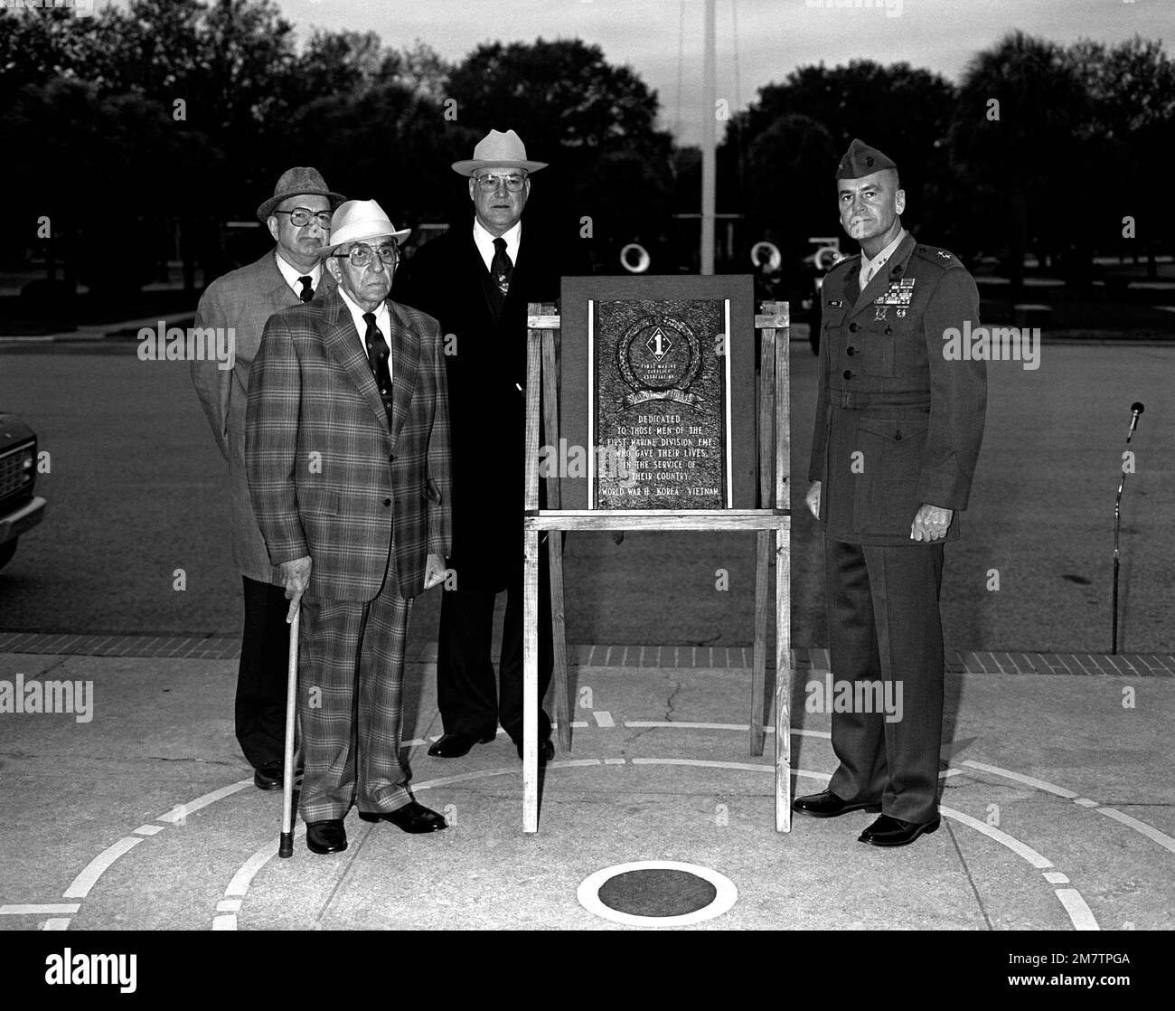 Retired GEN Edwin Pollok presents a plaque from the 1ST Marine Division ...