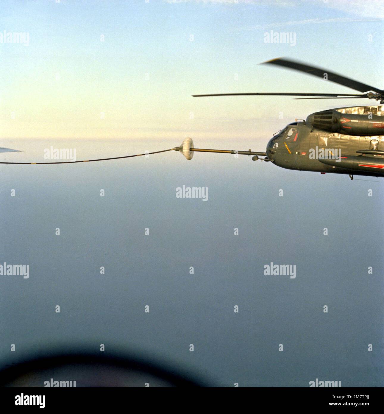 A left side view of an RH-53D Sea Stallion helicopter being refueled by ...