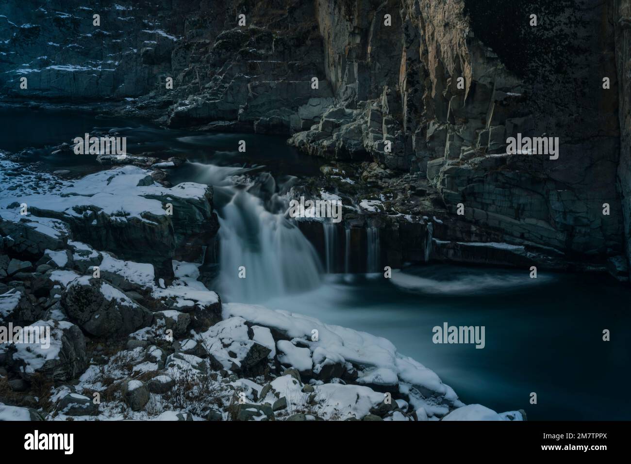 A long exposure shot of partially frozen Aharbal waterfall during a ...