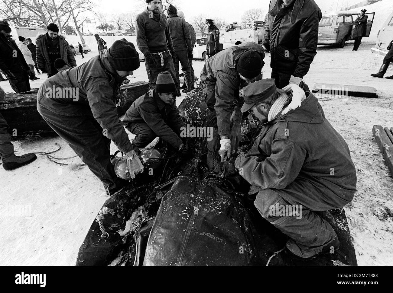 Navy divers inflate a rubber raft to be used in the location and ...