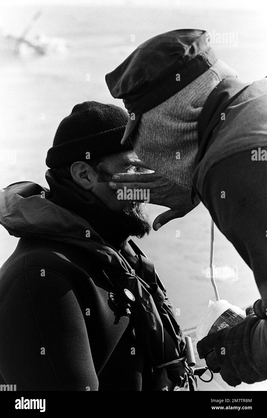 Petroleum jelly is applied to a diver's face to protect him from fuel ...