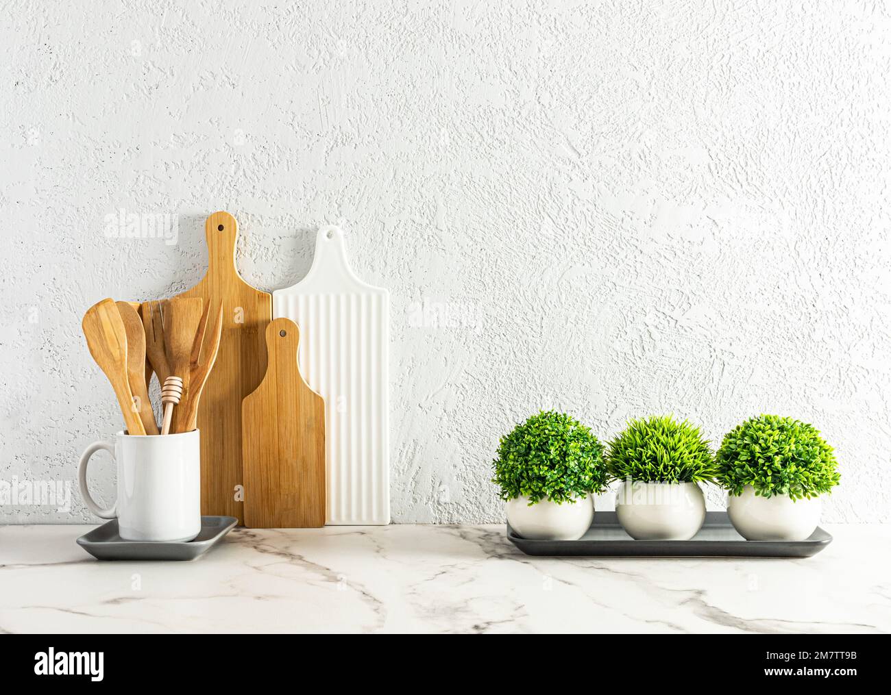 Stylish white kitchen background with various cutting boards and ...