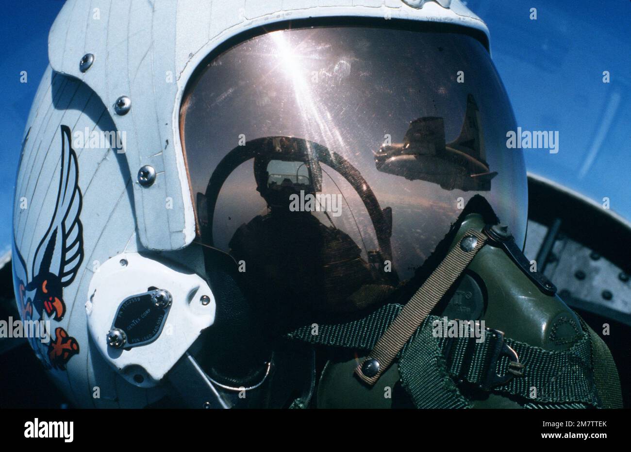The reflection of an aircraft is visible in the helmet of a pilot from ...