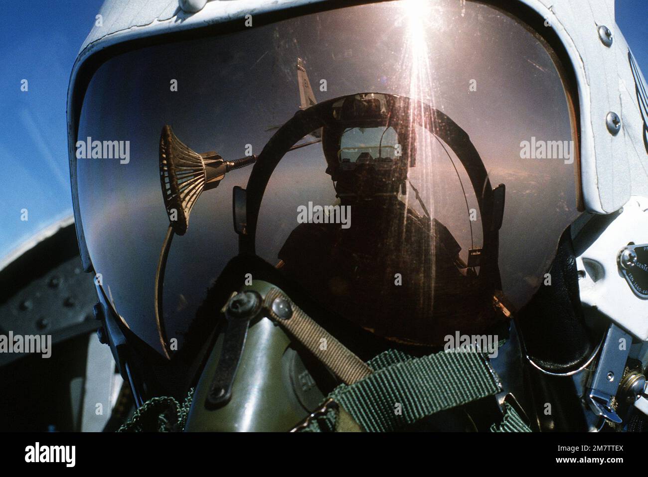 The reflection of an aircraft is visible in the helmet of a pilot from ...