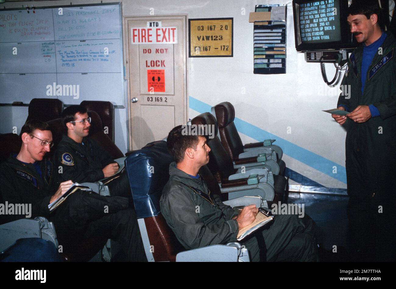 Pilots from Airborne-Early-Warning Squadron 123 (VAW-123) take notes in ...