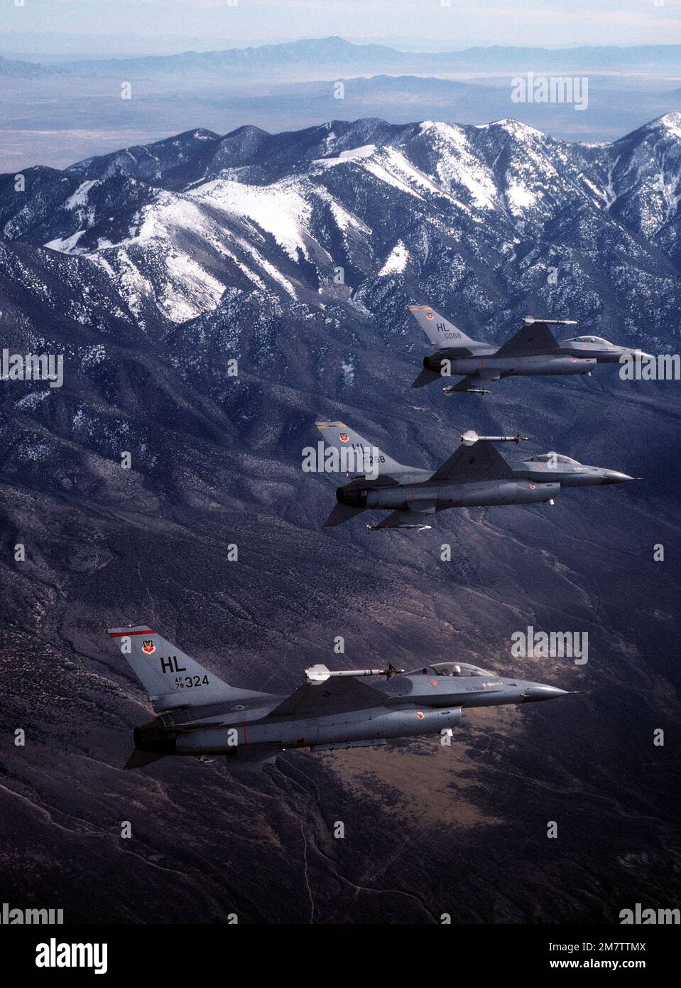 An air-to-air right side view of a three-ship echelon formation of F-16 ...