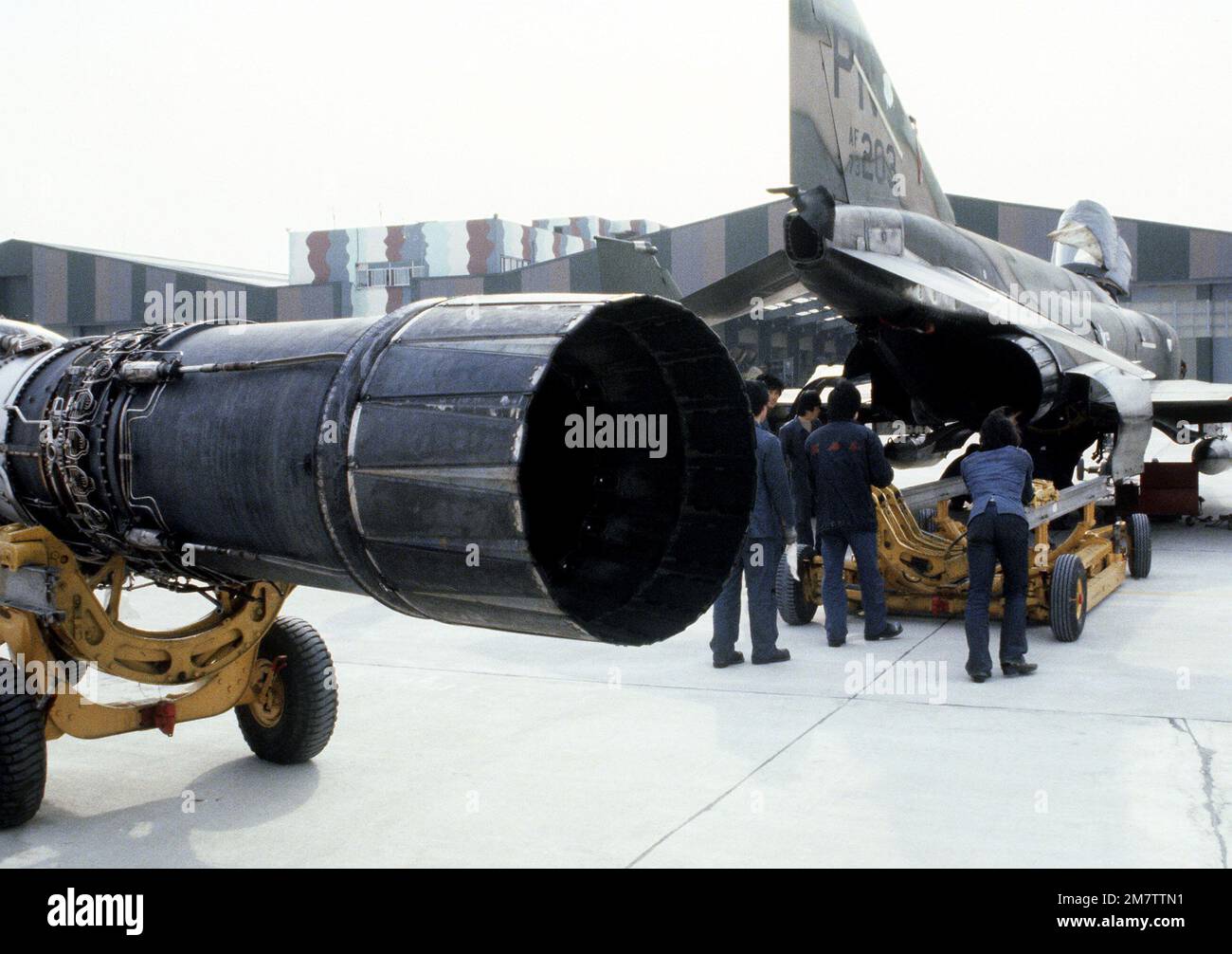 Korean specialists and Air Force maintenance technicians remove an ...