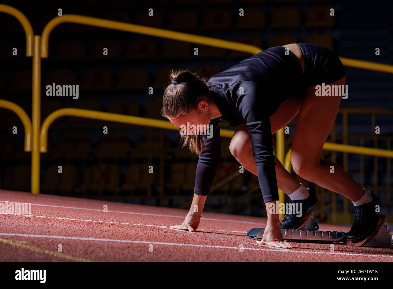 Young sportswoman at the starting blocks before running sprint Stock ...