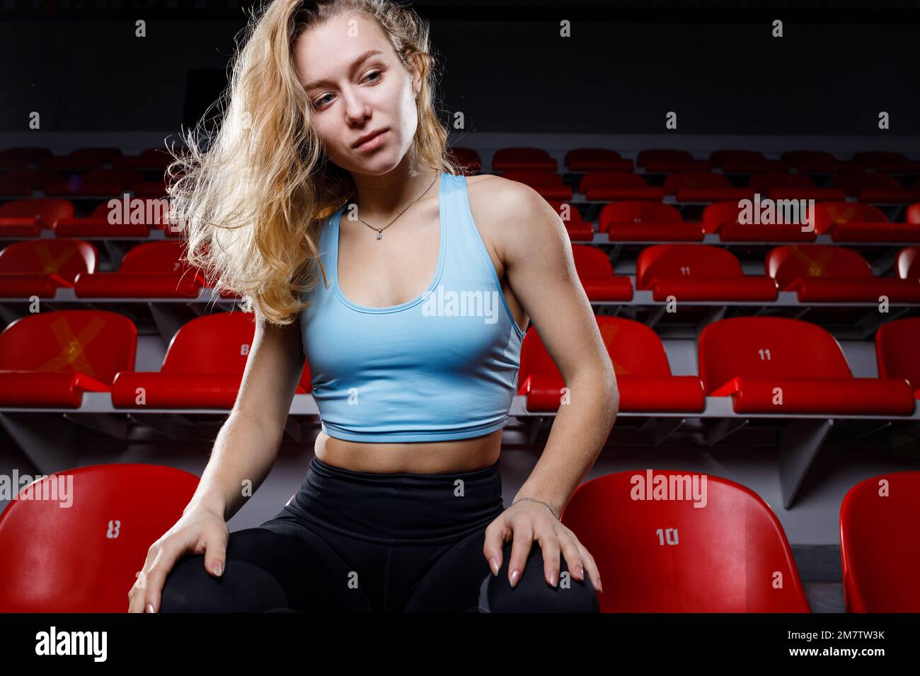 Young attractive fitness girl sitting in a tier of seats Stock Photo ...