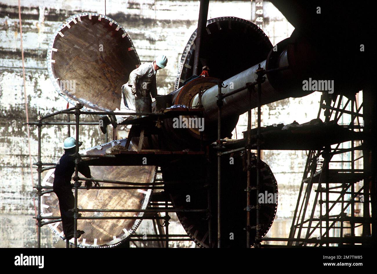 Shipyard personnel lubricate the strut bearings of the starboard screw ...