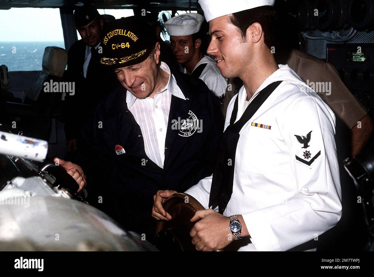 Secretary of Defense Caspar Weinberger, left, talks to a crewman on the ...