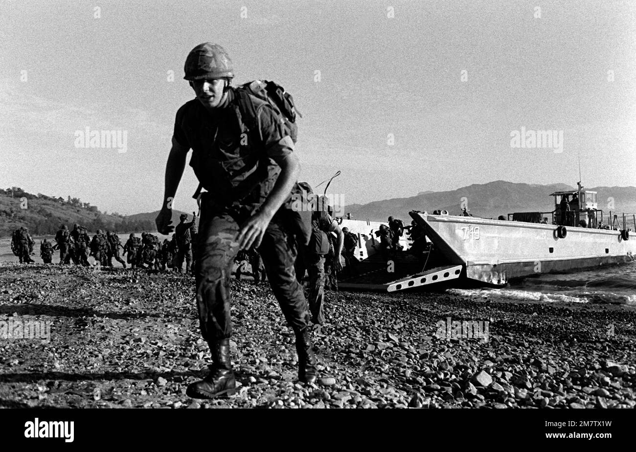 Marines deploy on a beach after being landed by mechanized landing ...