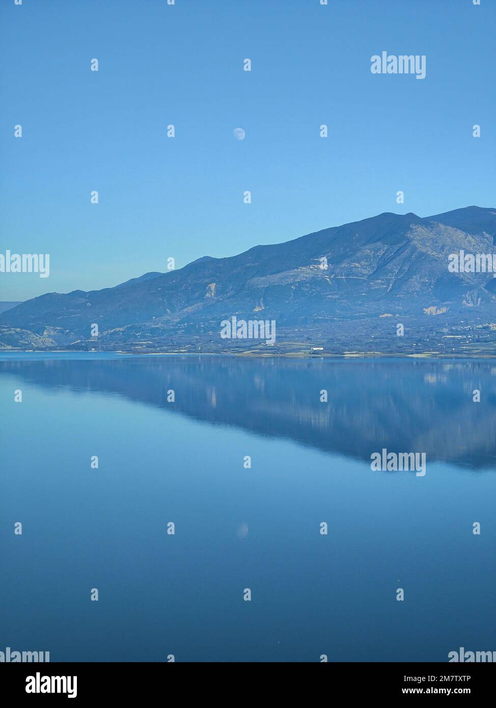 A vertical aerial view of a beautiful lake reflecting the mountain with ...