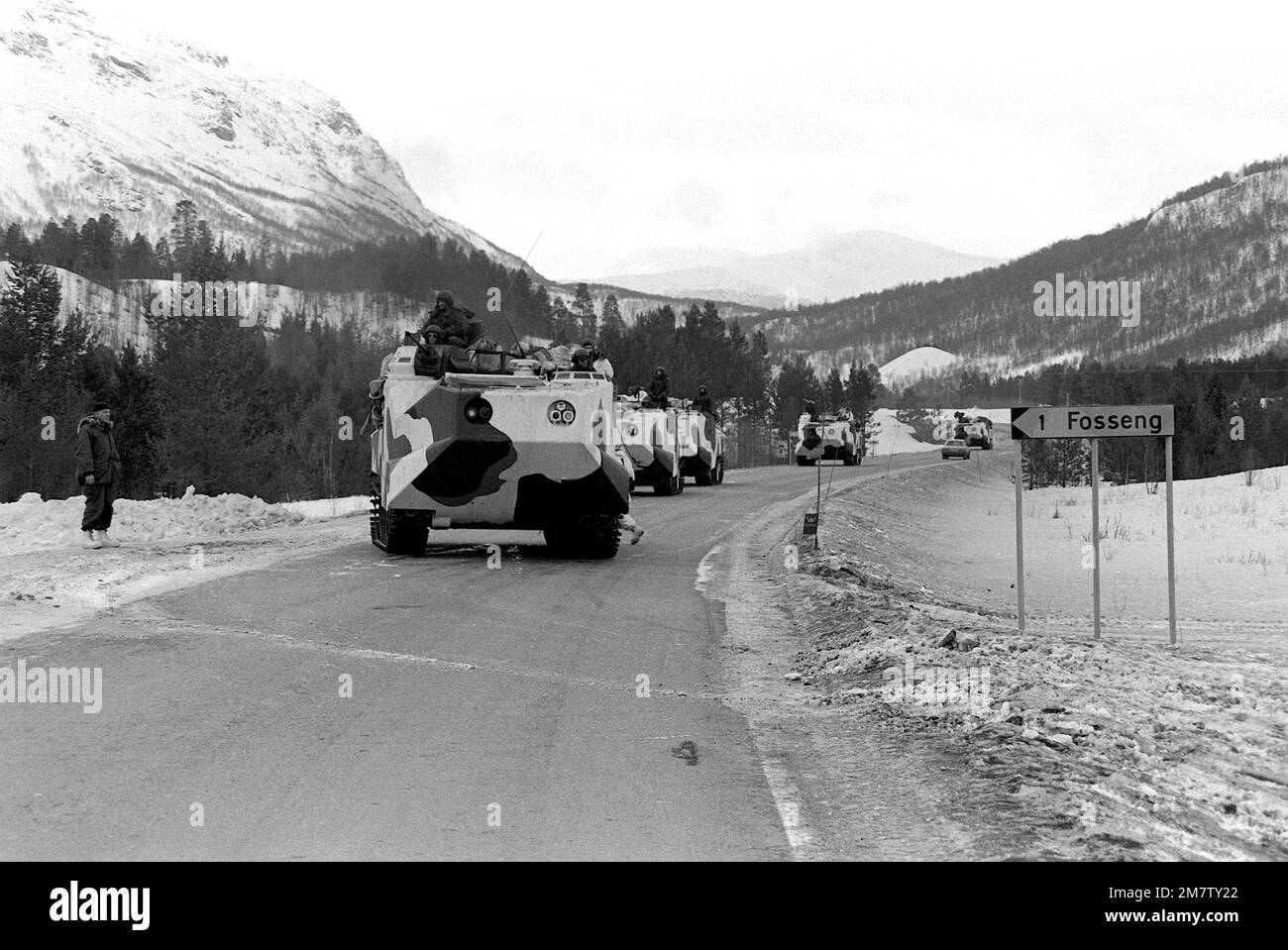 A formation of LVTP-7 tracked landing vehicles carrying troops moves ...