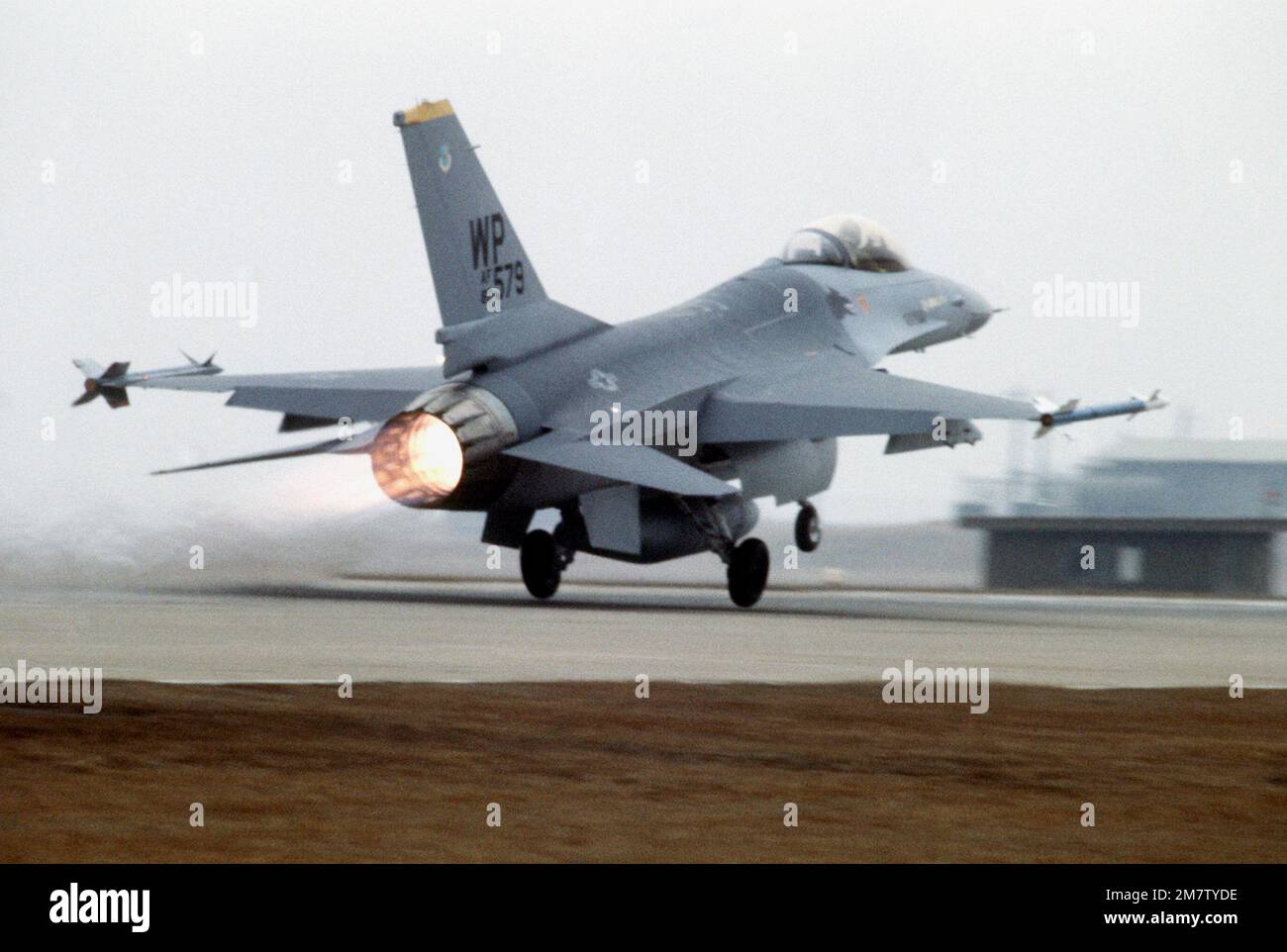 Right rear view of an F-16 Fighting Falcon aircraft taking off during ...