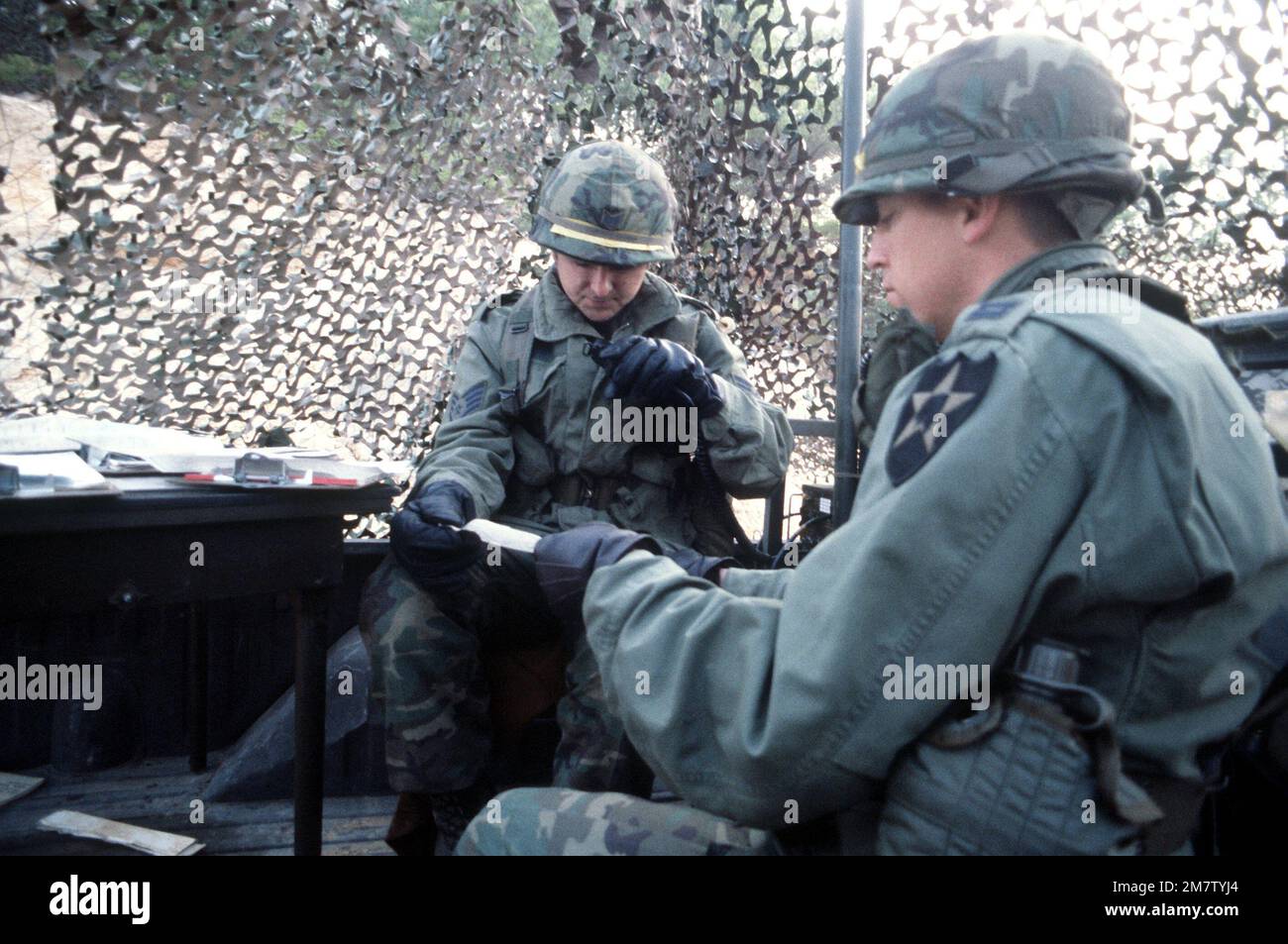 SSGT Brian Logie and CPT Alan Cox work on a weather report during ...