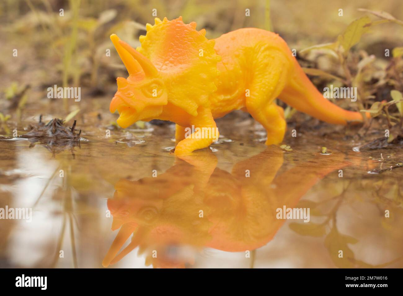 dinosaur toys illustrating loitering around the lake Stock Photo - Alamy