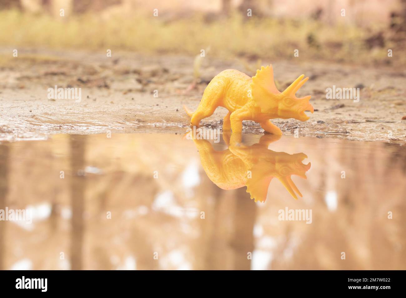 dinosaur toys illustrating loitering around the lake Stock Photo - Alamy