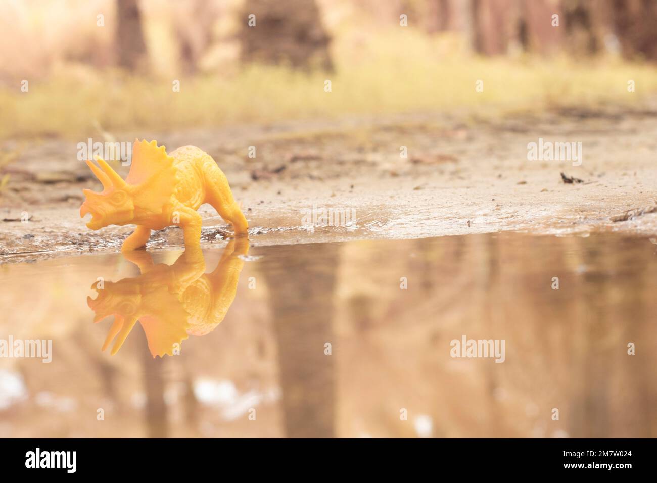 dinosaur toys illustrating loitering around the lake Stock Photo - Alamy
