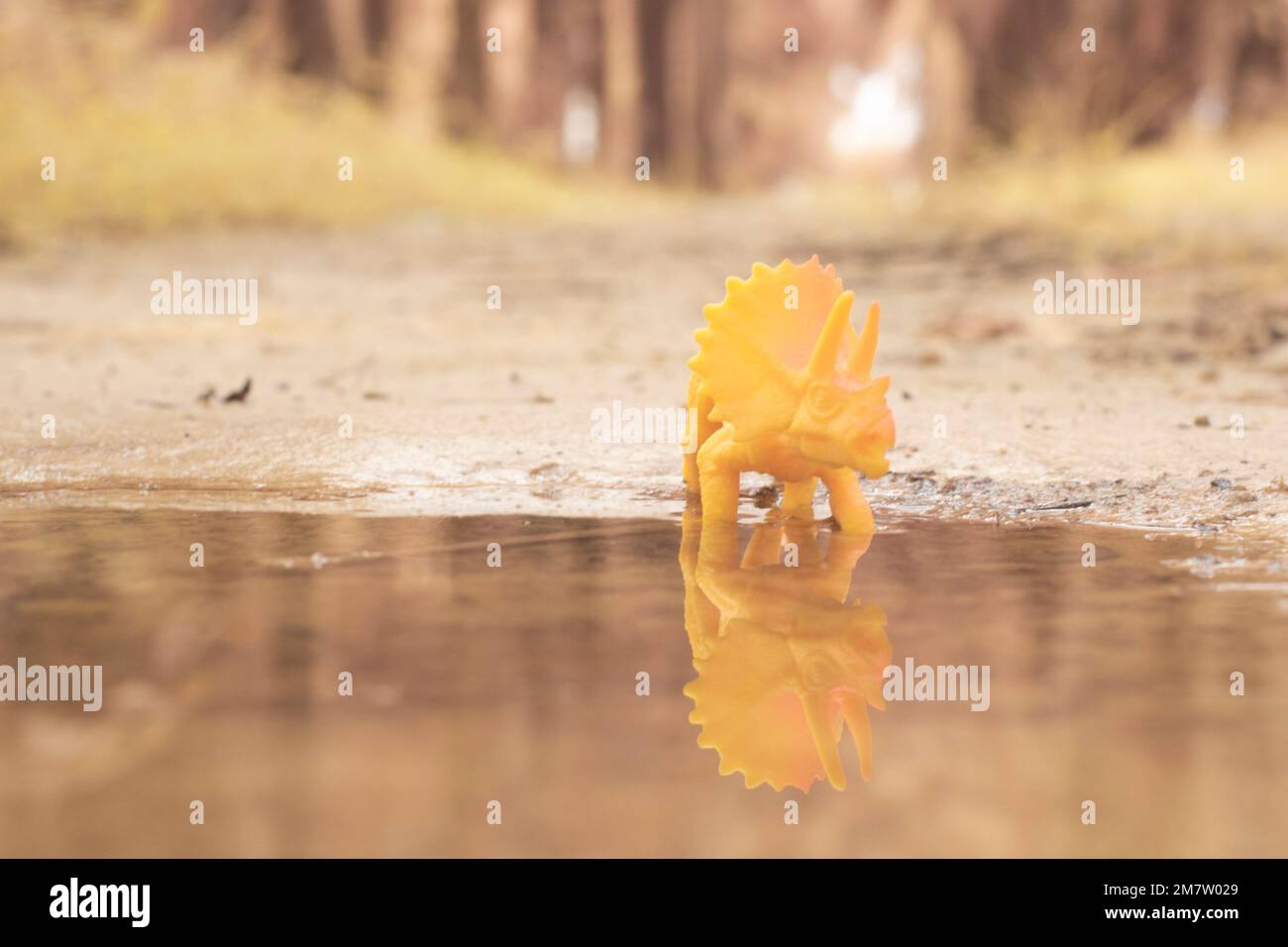 dinosaur toys illustrating loitering around the lake Stock Photo - Alamy