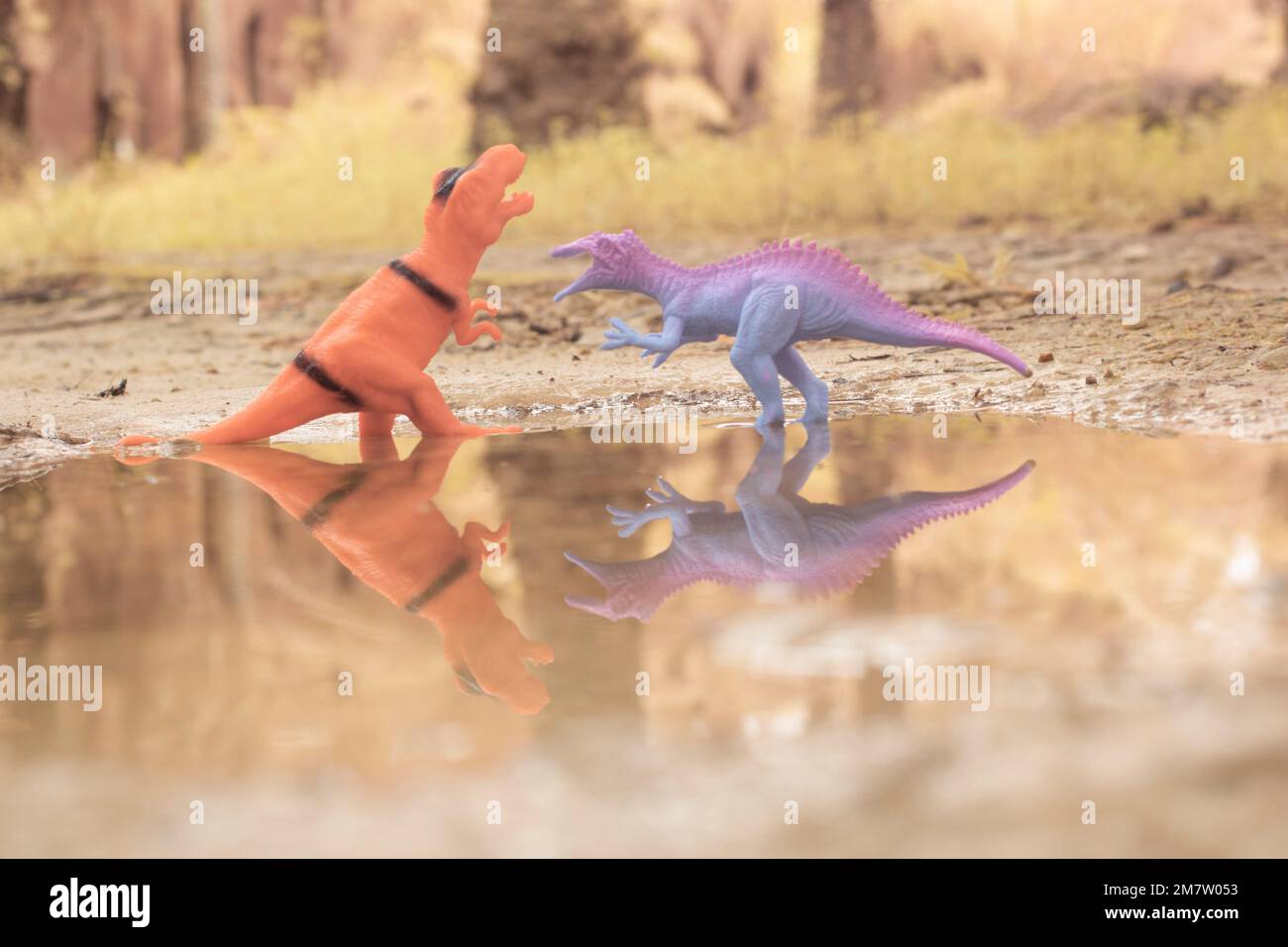 dinosaur toys illustrating loitering around the lake Stock Photo - Alamy