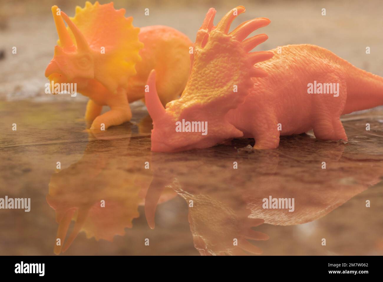 dinosaur toys illustrating loitering around the lake Stock Photo - Alamy