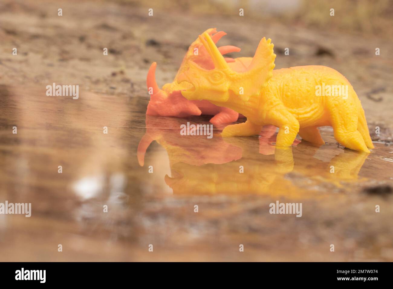 dinosaur toys illustrating loitering around the lake Stock Photo - Alamy