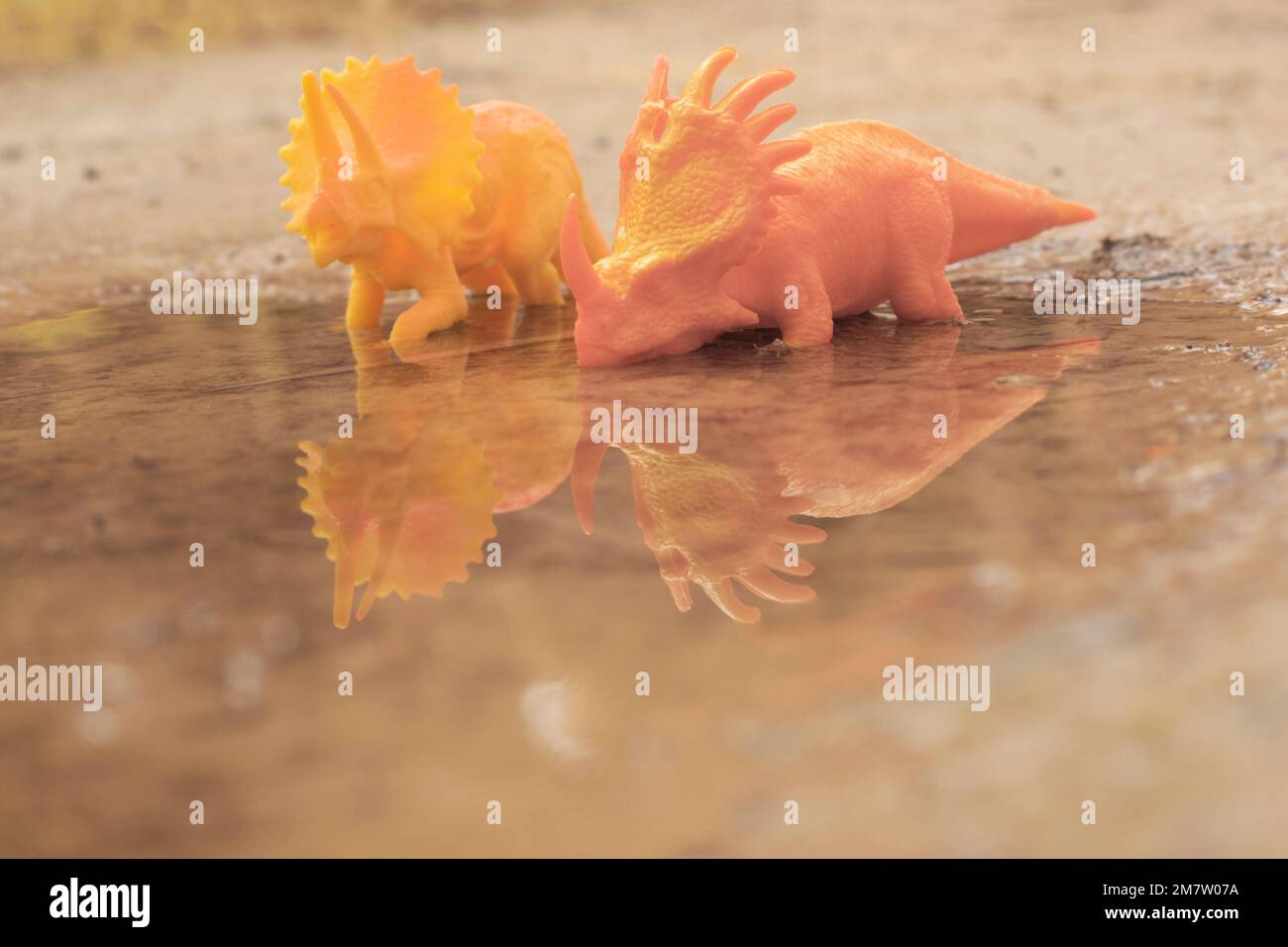 dinosaur toys illustrating loitering around the lake Stock Photo - Alamy