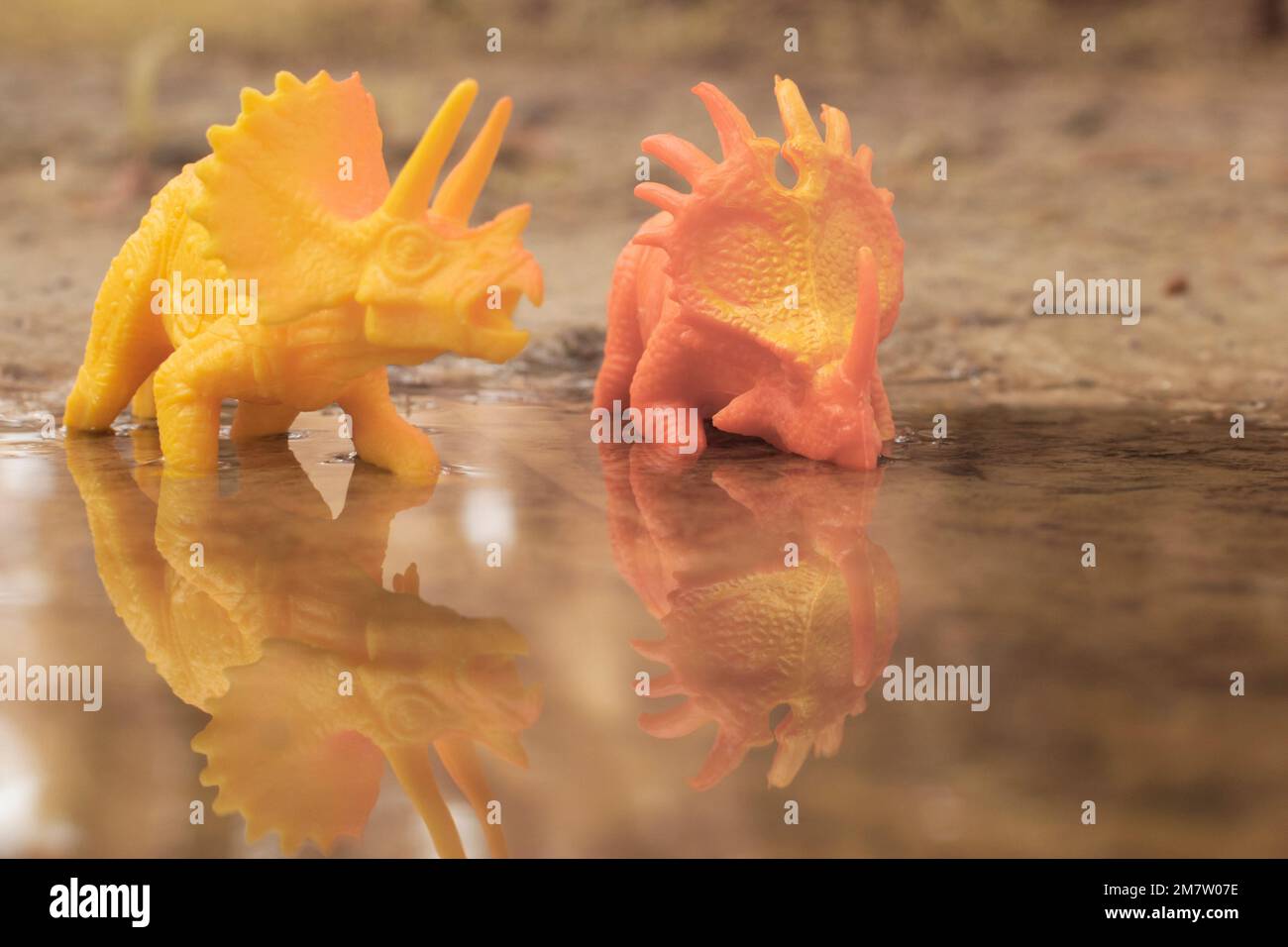 dinosaur toys illustrating loitering around the lake Stock Photo - Alamy