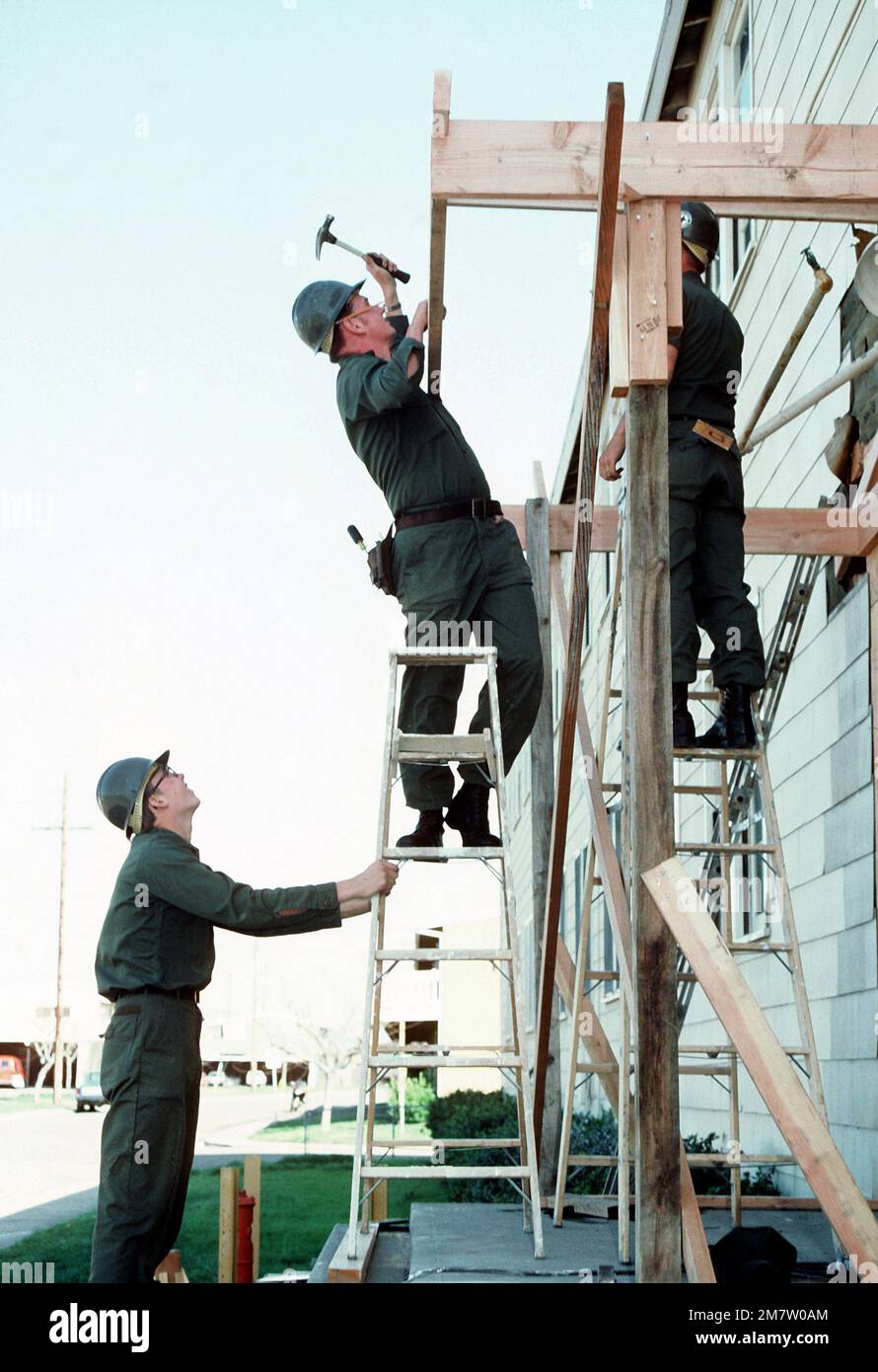 Seabees from Construction Battalion 416 add a porch roof to a building ...