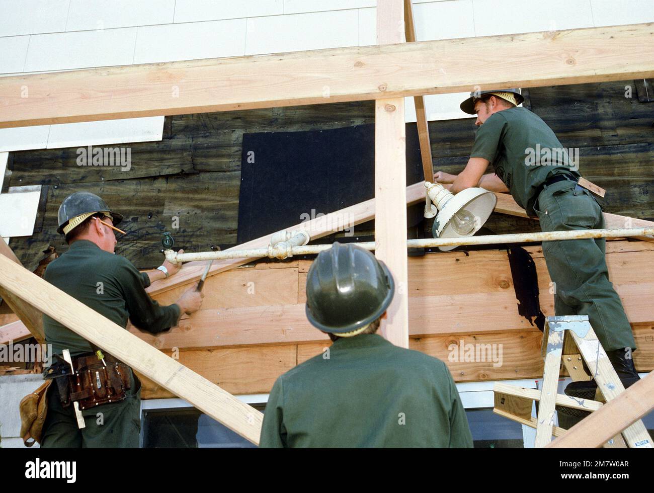 Seabees from Construction Battalion 416 add a porch roof to a building ...